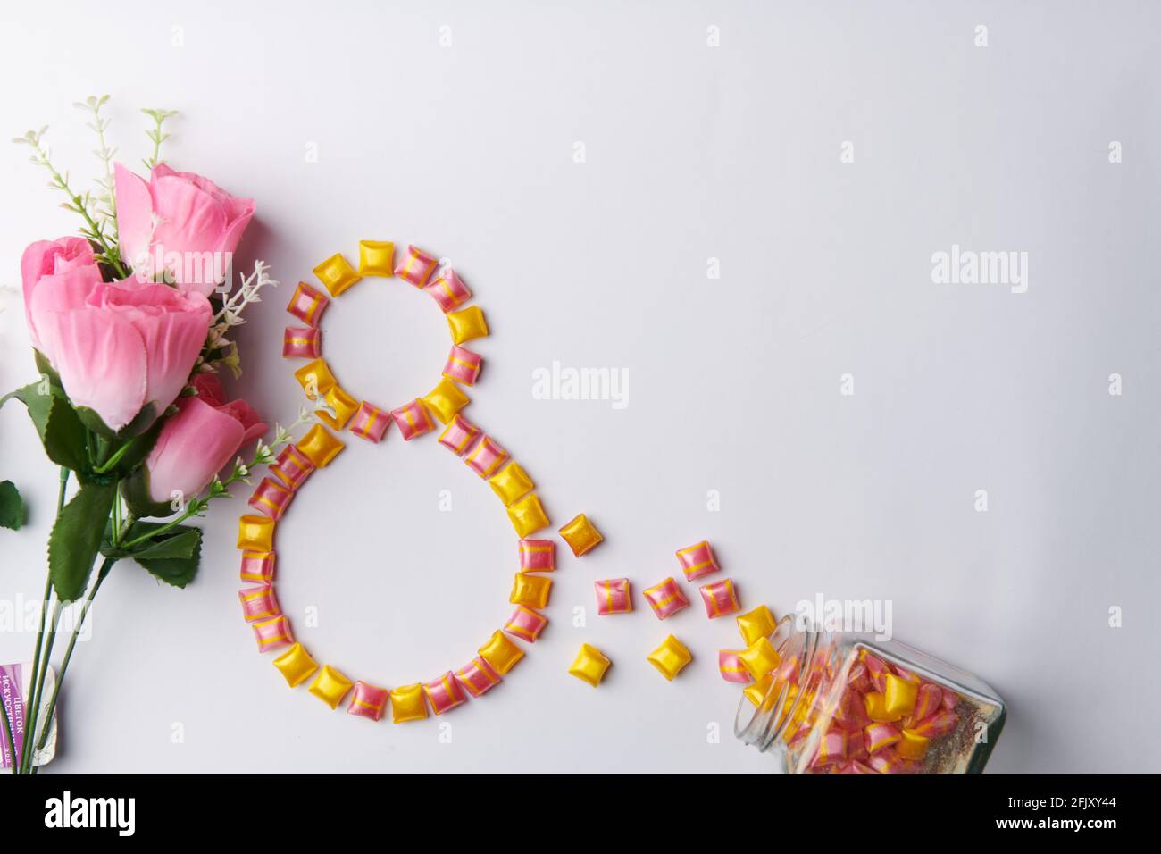 jar with scattered candies and a bouquet of pink roses number eight ...