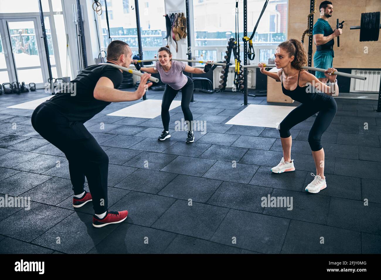 Fitness instructor and his female clients working out together Stock ...