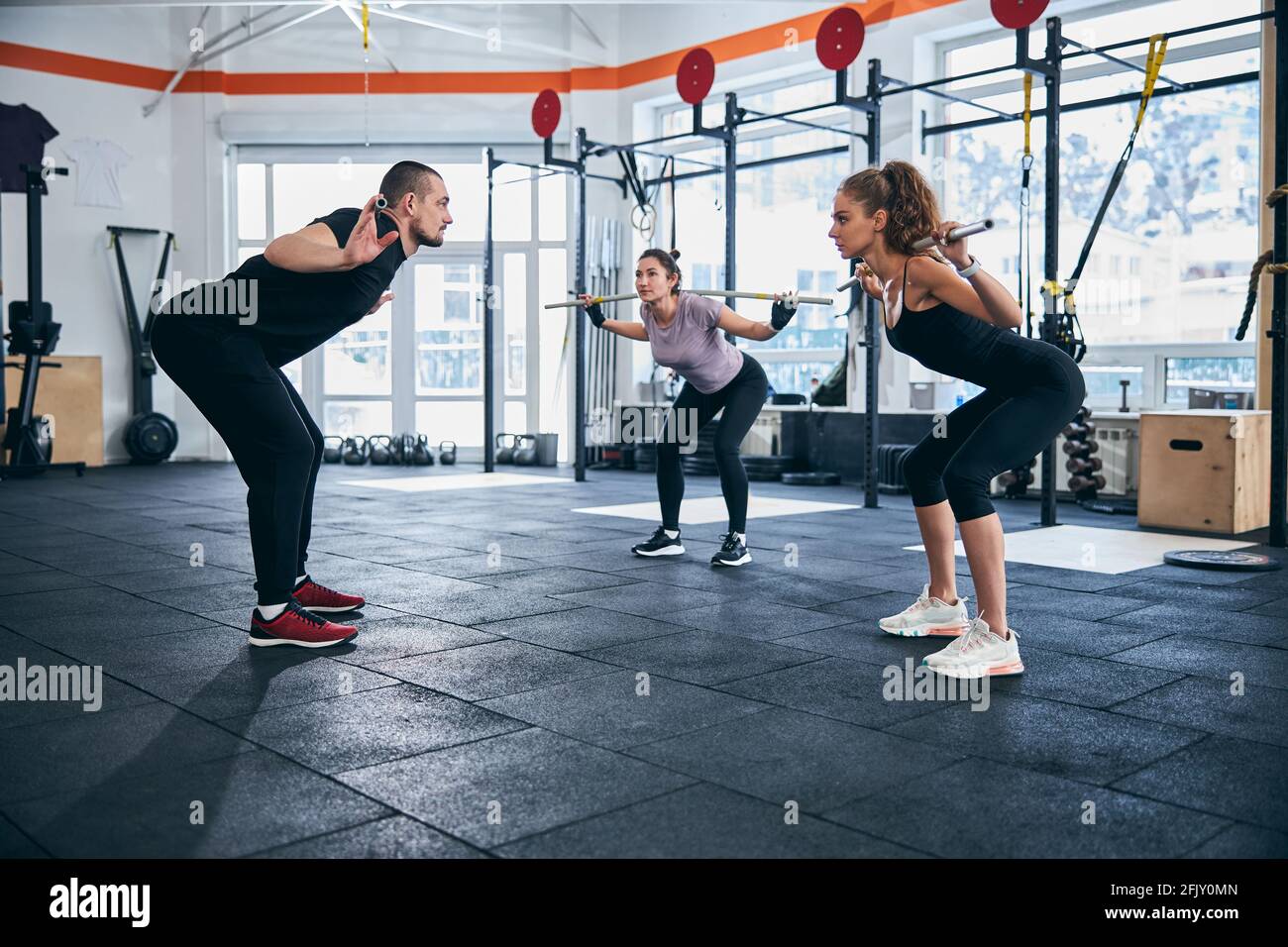 Qualified trainer instructing his clients during the training session ...