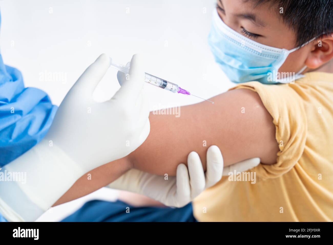 Doctor making a vaccination in the shoulder of patient boy or child ...