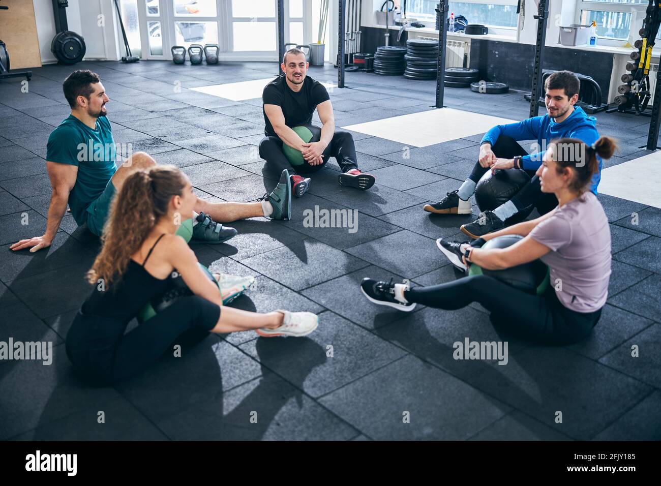 Joyous coach communicating with young athletes indoors Stock Photo - Alamy