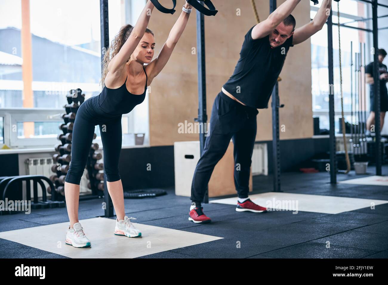 Two sportspeople doing back stretches at the gym Stock Photo - Alamy