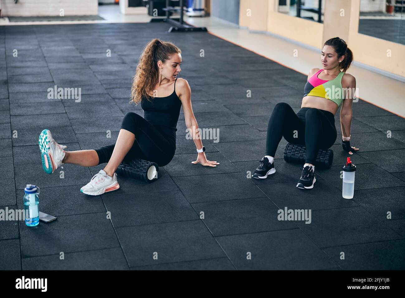 Two ladies sitting on the floor during the workout Stock Photo - Alamy