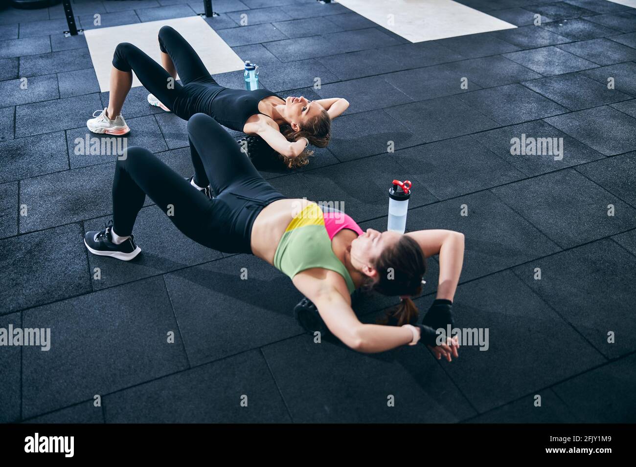 Sportswomen performing a foam rolling exercise on the floor Stock Photo ...
