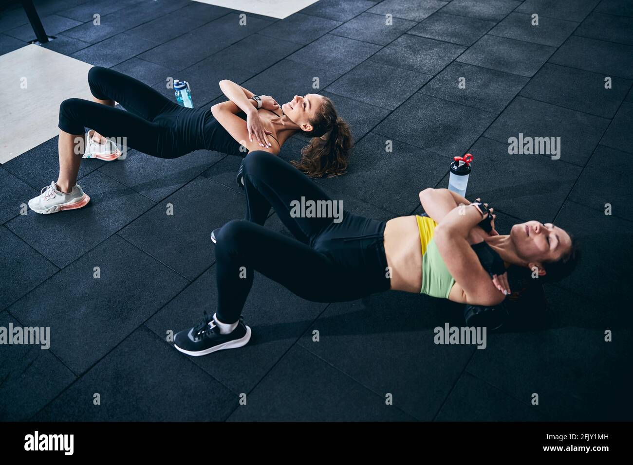 Two Caucasian sportswomen performing the crossed arm roll Stock Photo ...