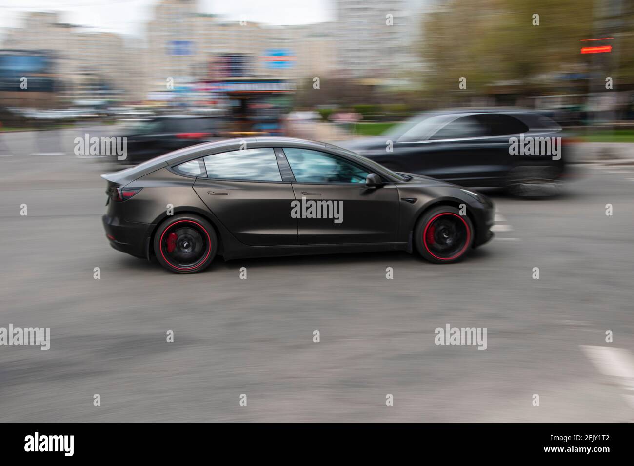Ukraine, Kyiv - 20 April 2021: Brown TESLA Model 3 car moving on the ...