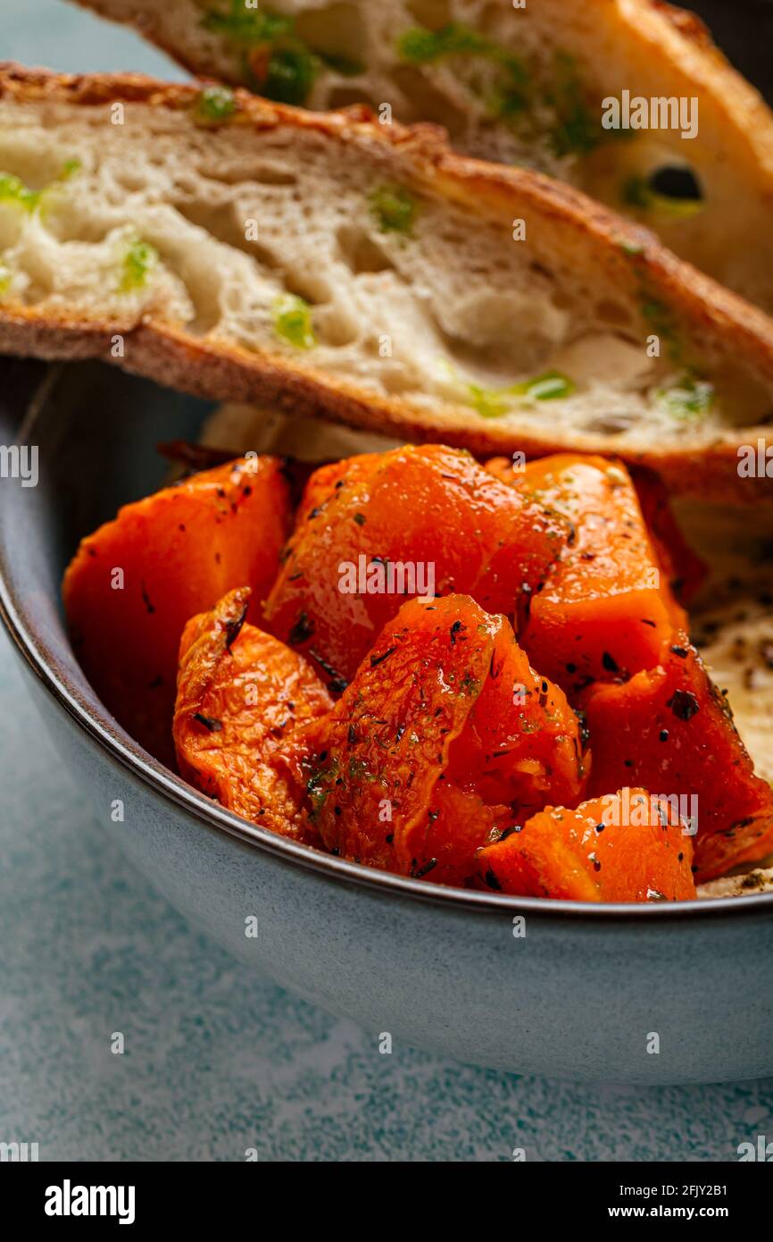Hummus with honey pumpkin zaatar and crispy bucket Stock Photo - Alamy