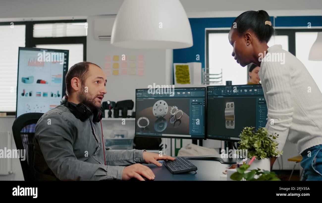 Mechanical engineer working on computer designing in CAD software 3D model of engine while ...