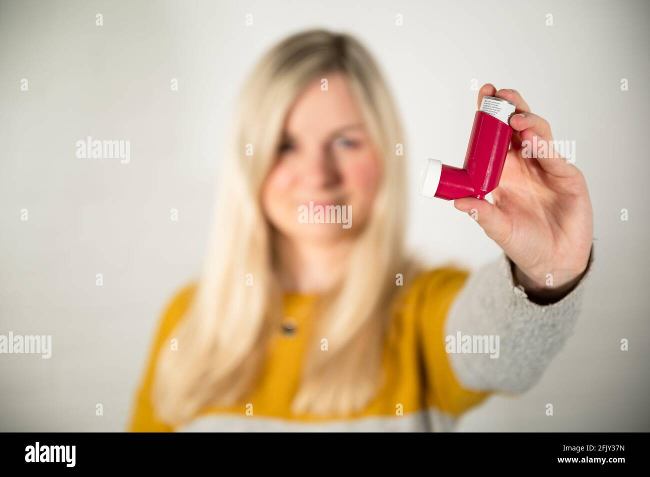Young blonde woman holding an asthma spray inhaler in her hand Stock ...