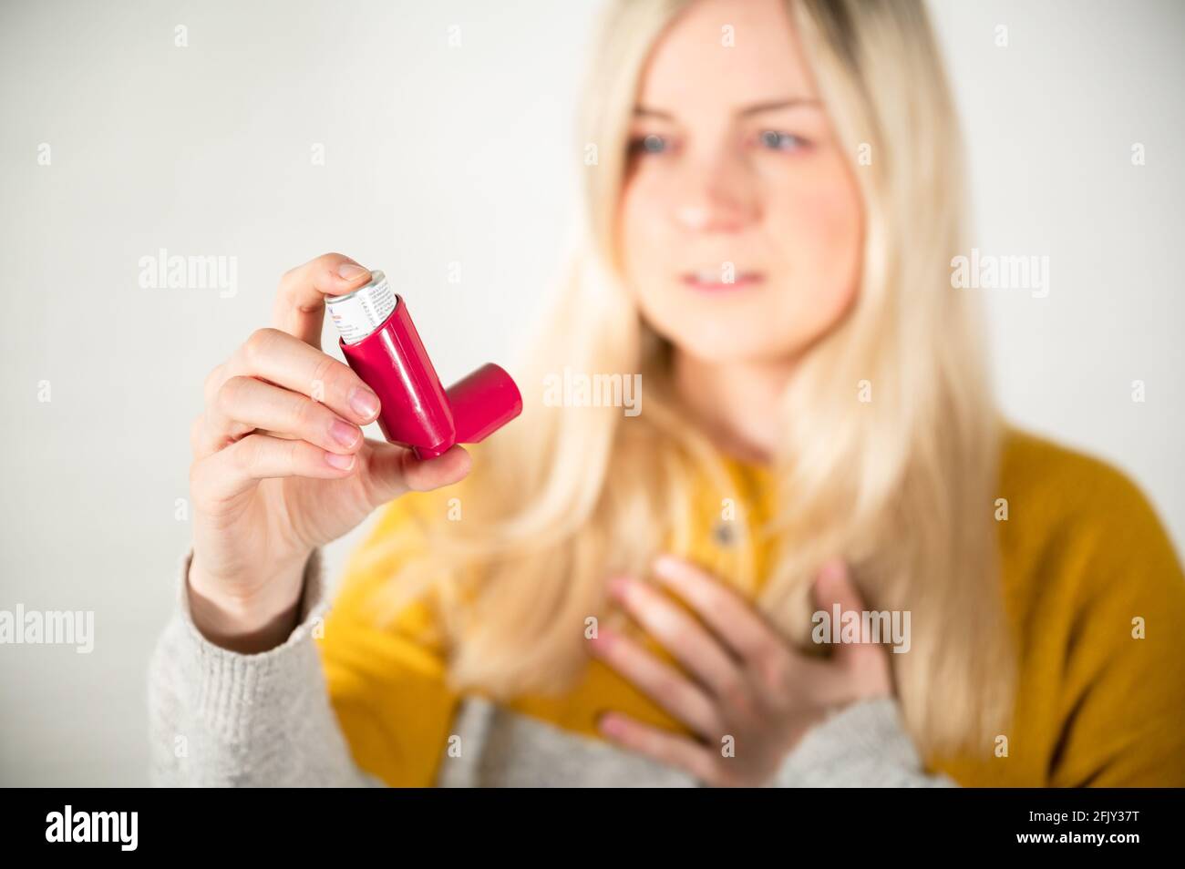 Young Blonde Woman Holding An Asthma Spray Inhaler In Her Hand Stock