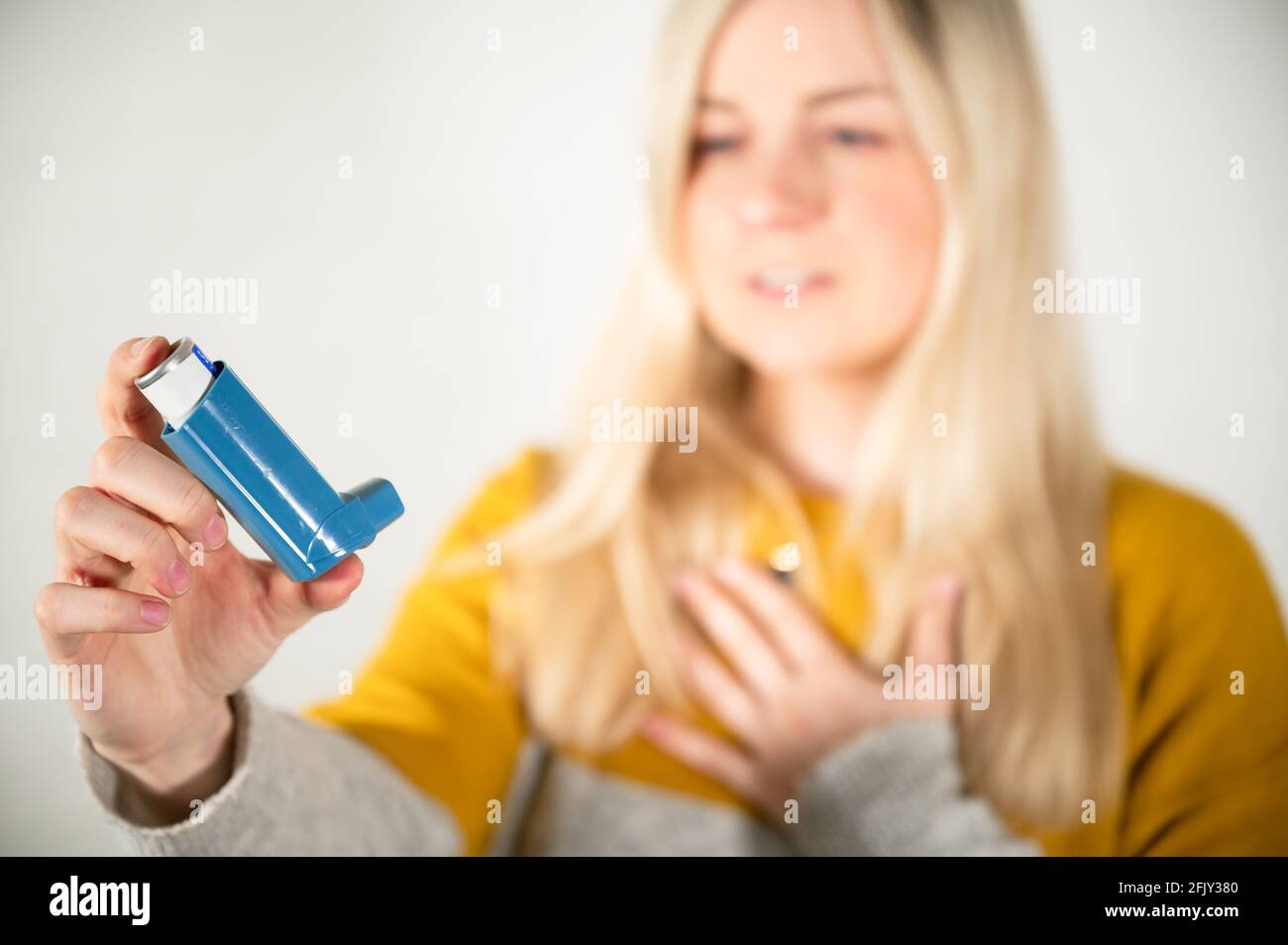 Young blonde woman holding an asthma spray inhaler in her hand Stock ...