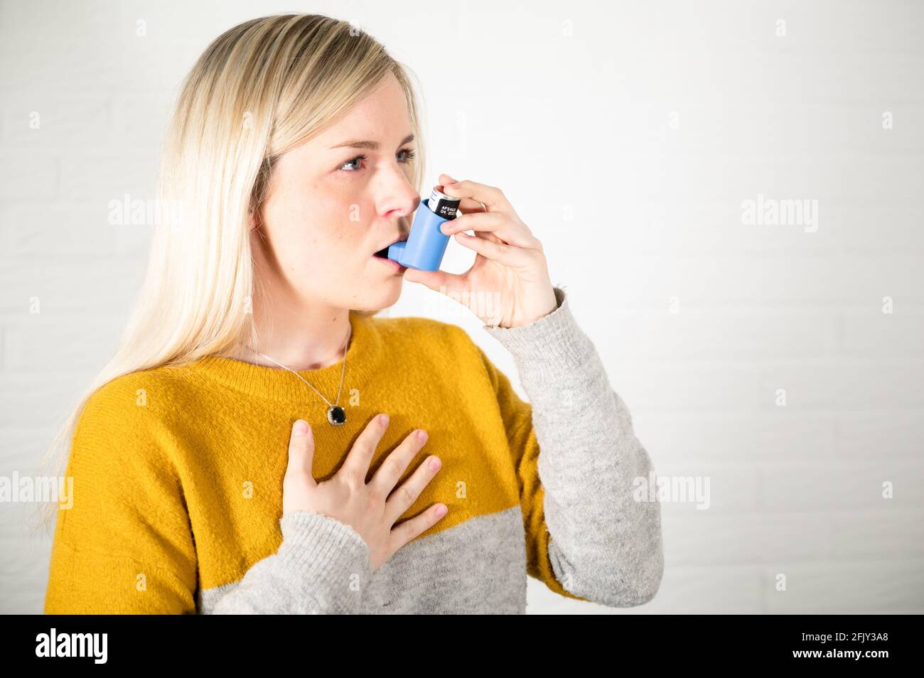 Young blonde woman holding an asthma spray inhaler in her hand Stock ...