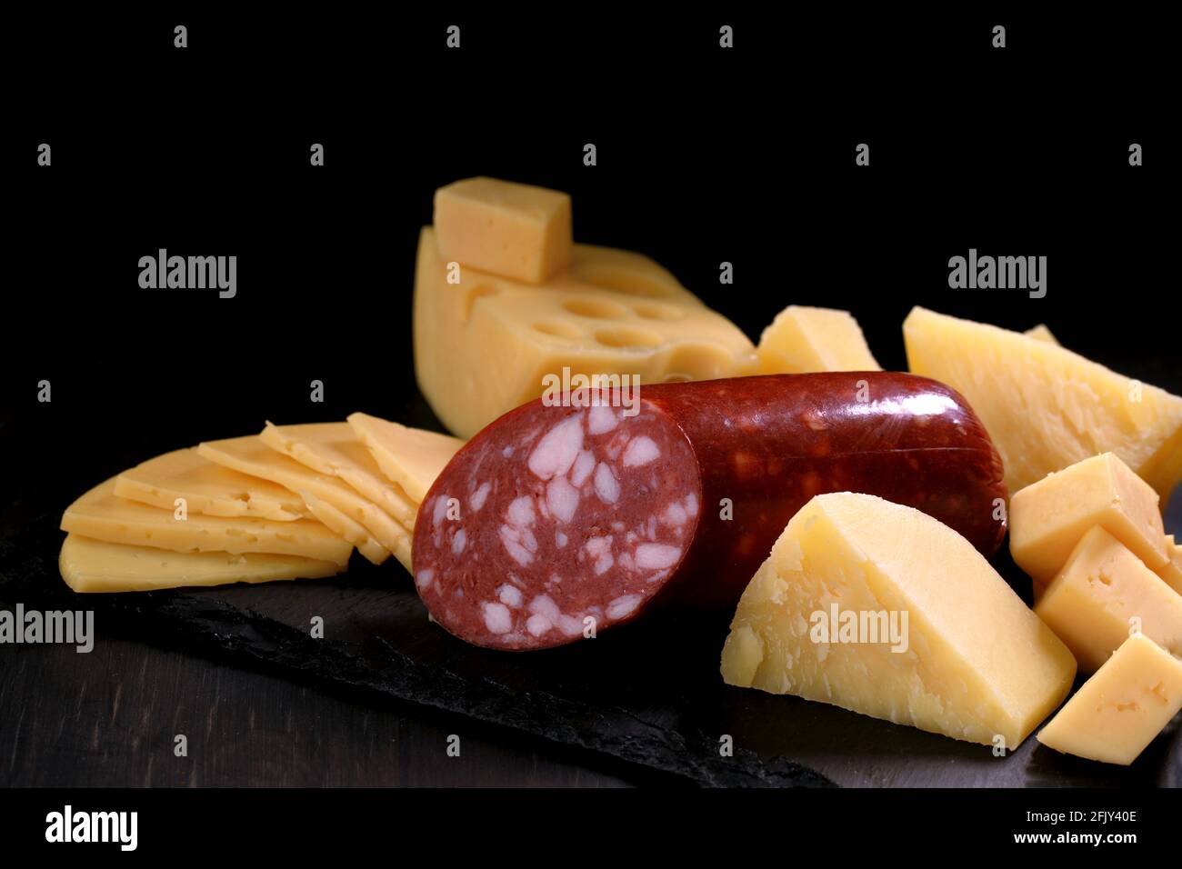 Several types of yellow cheese in chunks and cut into slices and piece ...
