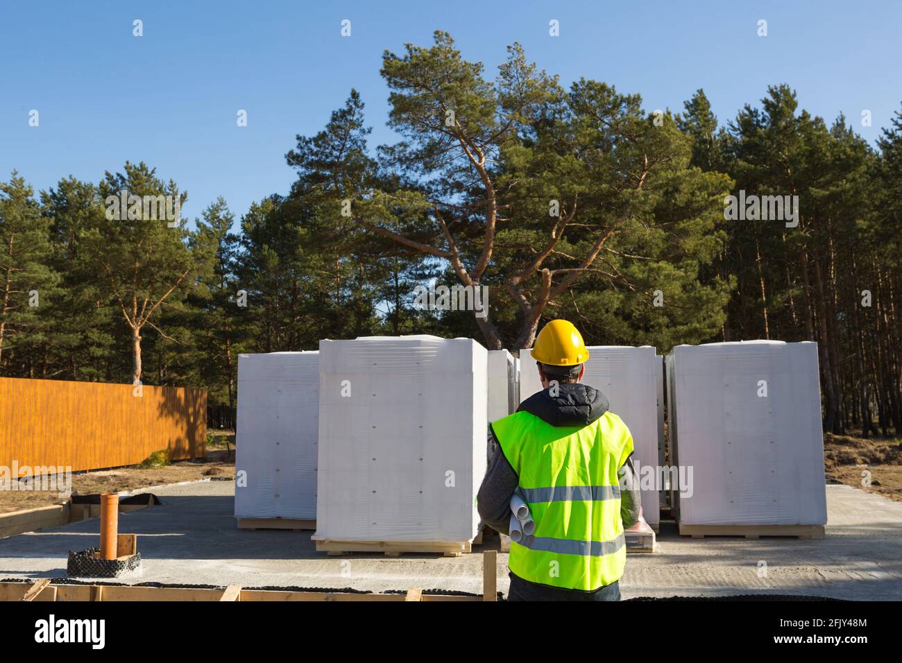 The project architect's back is on the construction site of a house ...