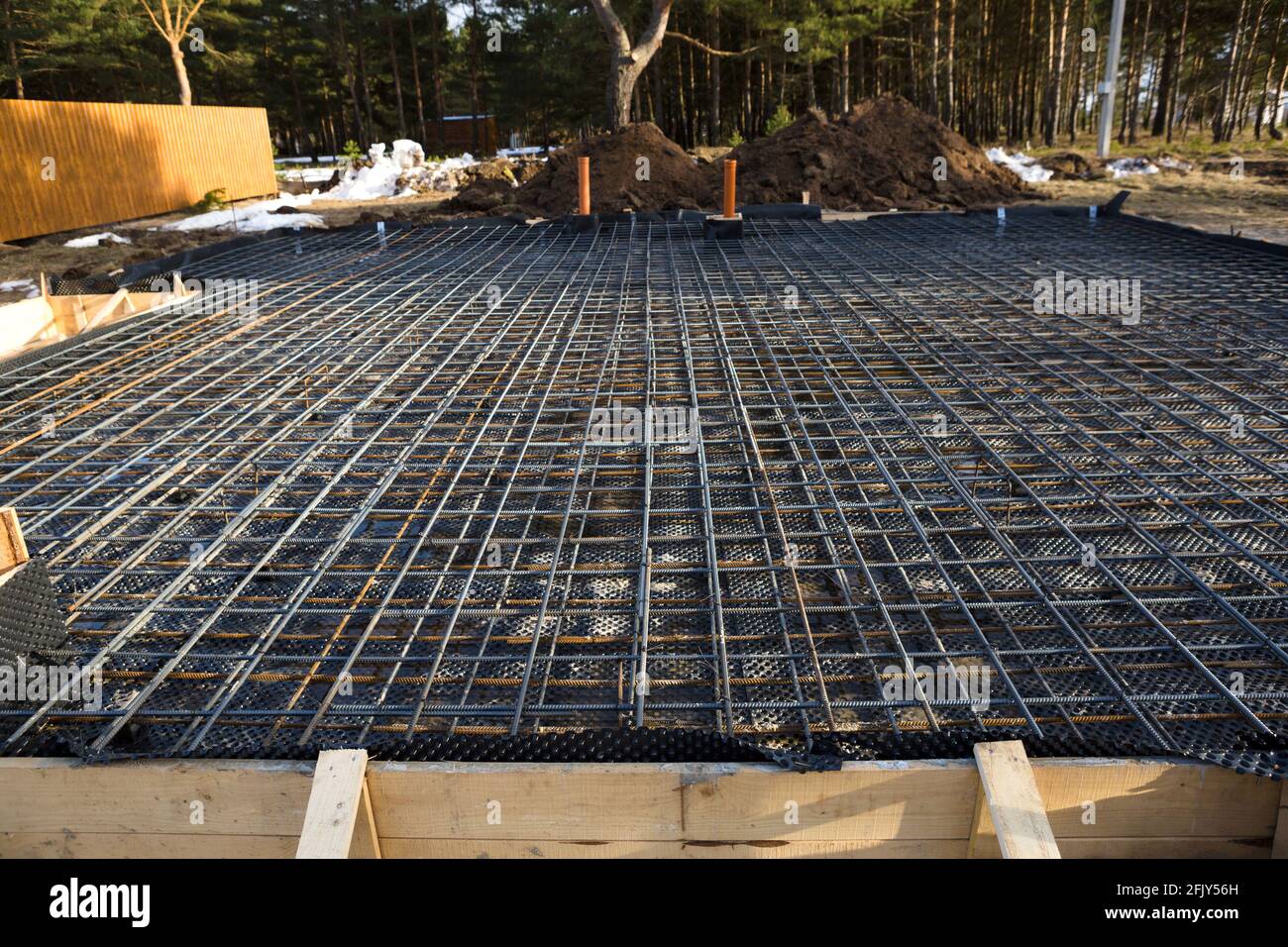 Iron fittings on a wooden blind area with laid pipes are the basis for ...