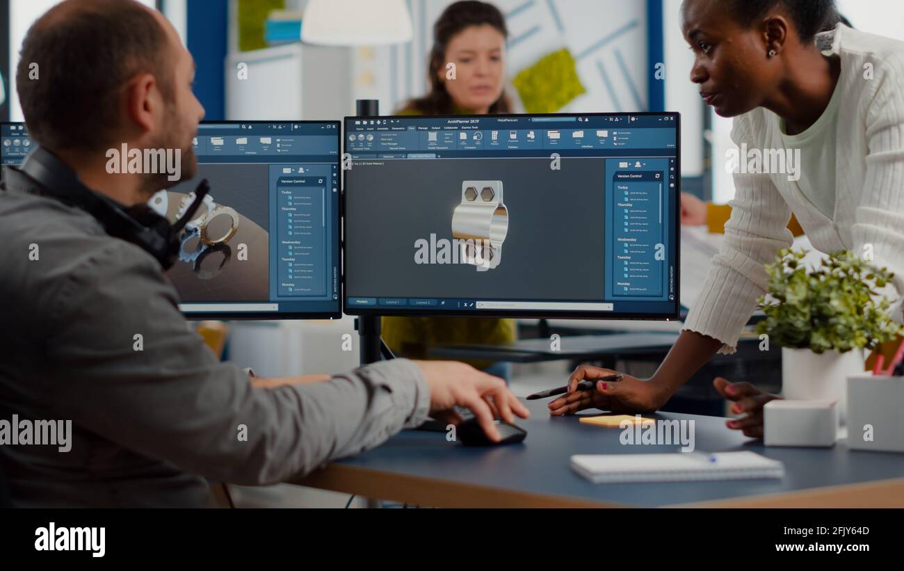 Diverse team discussing about industrial project using dual monitors ...