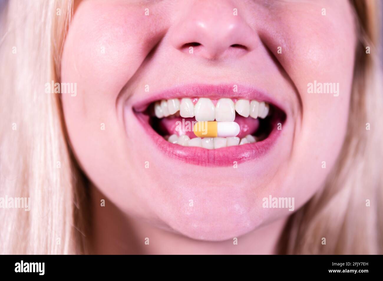 Blonde girl taking a pill - too much medicine Stock Photo - Alamy