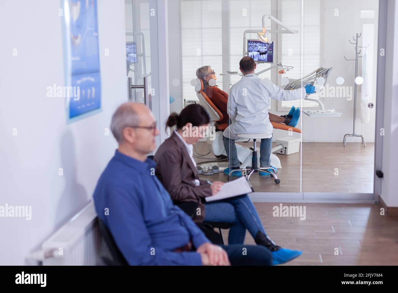 Dentist with senior patient analyzing teeth radiography x-ray in ...