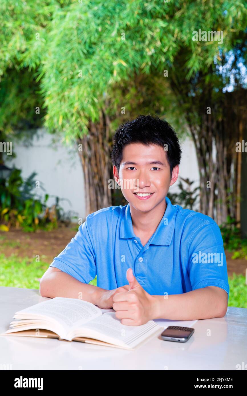 Young Chinese Asian student is successfully at home with difficult ...