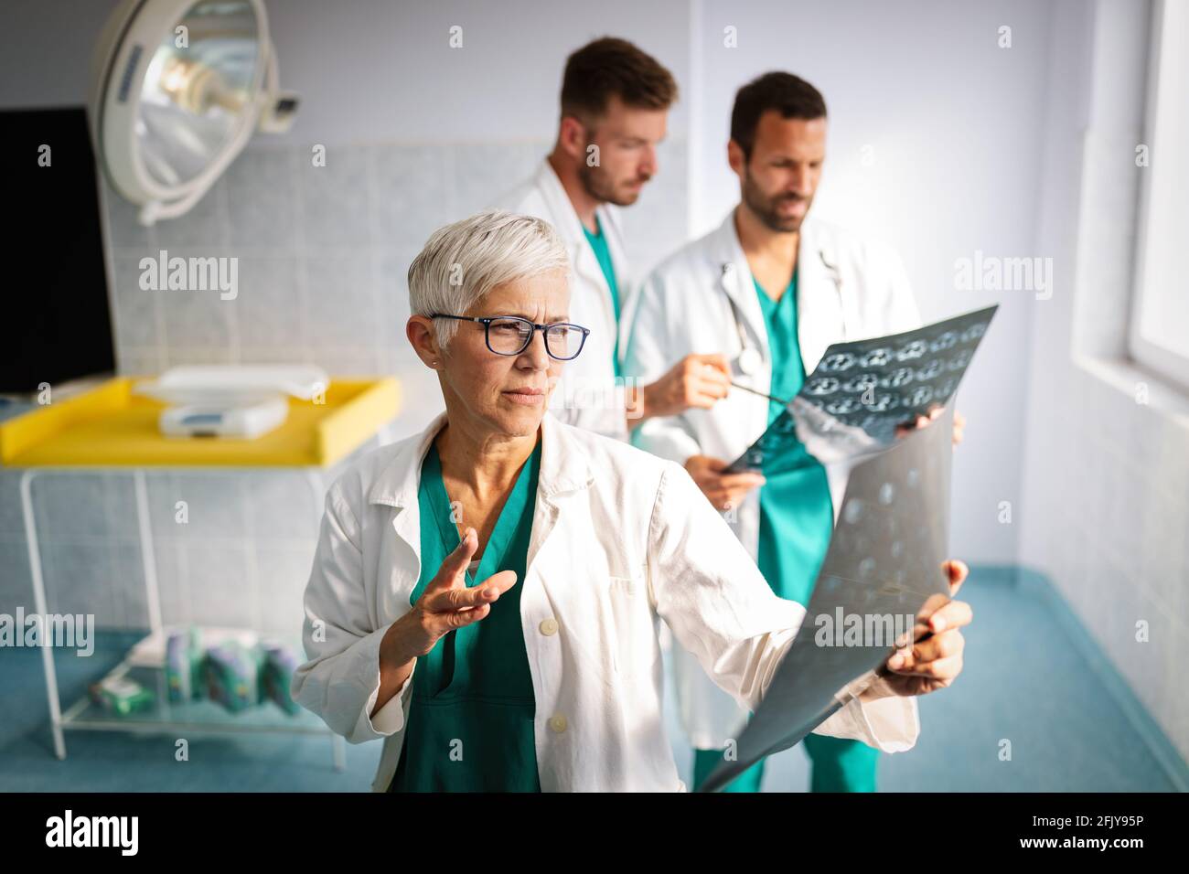 Group of doctors examining an x-ray in hospital to make diagnosis Stock ...