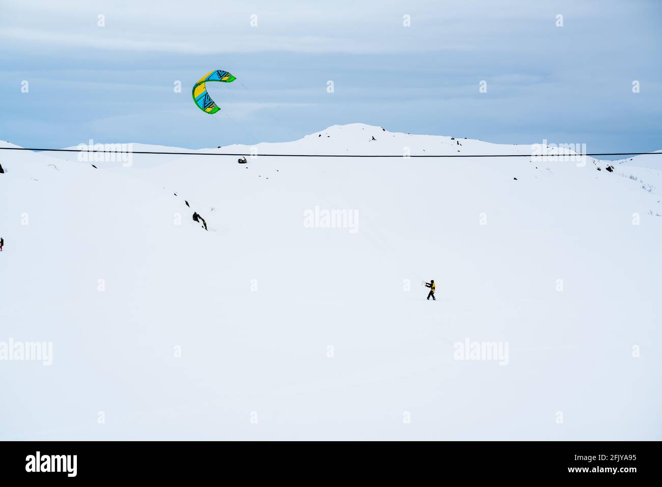 People Snowkiting on a frozen snowy mountain plain on a cold winters ...