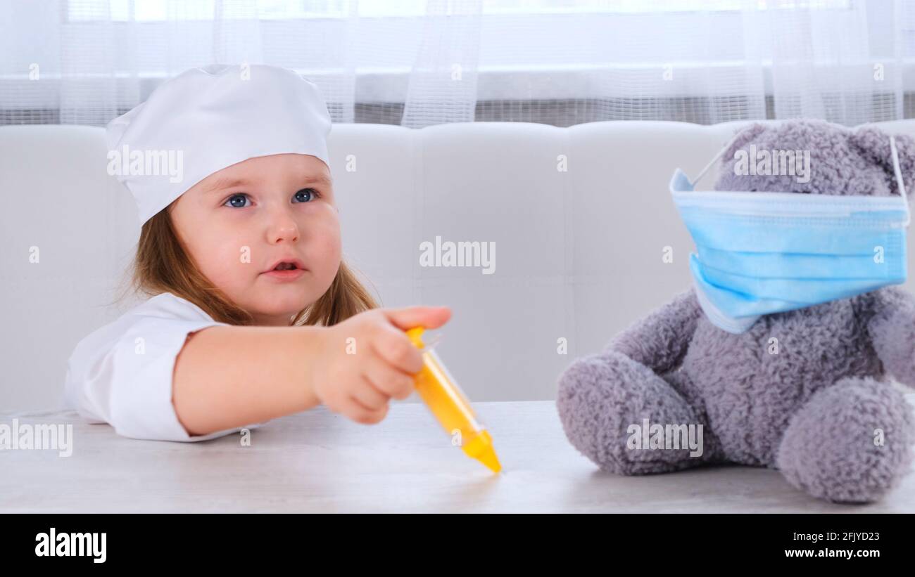little girl plays a doctor, makes an injection. Happy child little ...