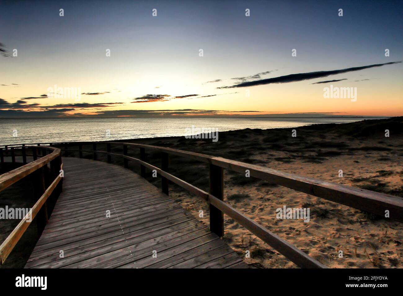 Wooden walkway to Arenales del Sol beach in a beautiful with sunrise ...