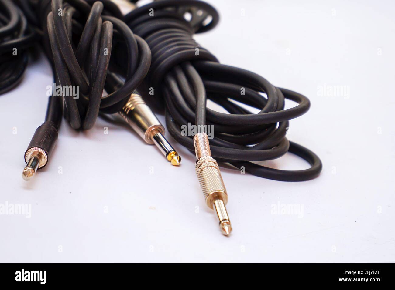 Audio cables for musical instruments and microphones on a white ...