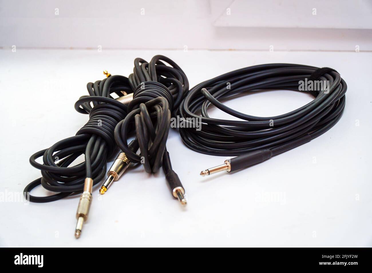 Audio cables for musical instruments and microphones on a white ...