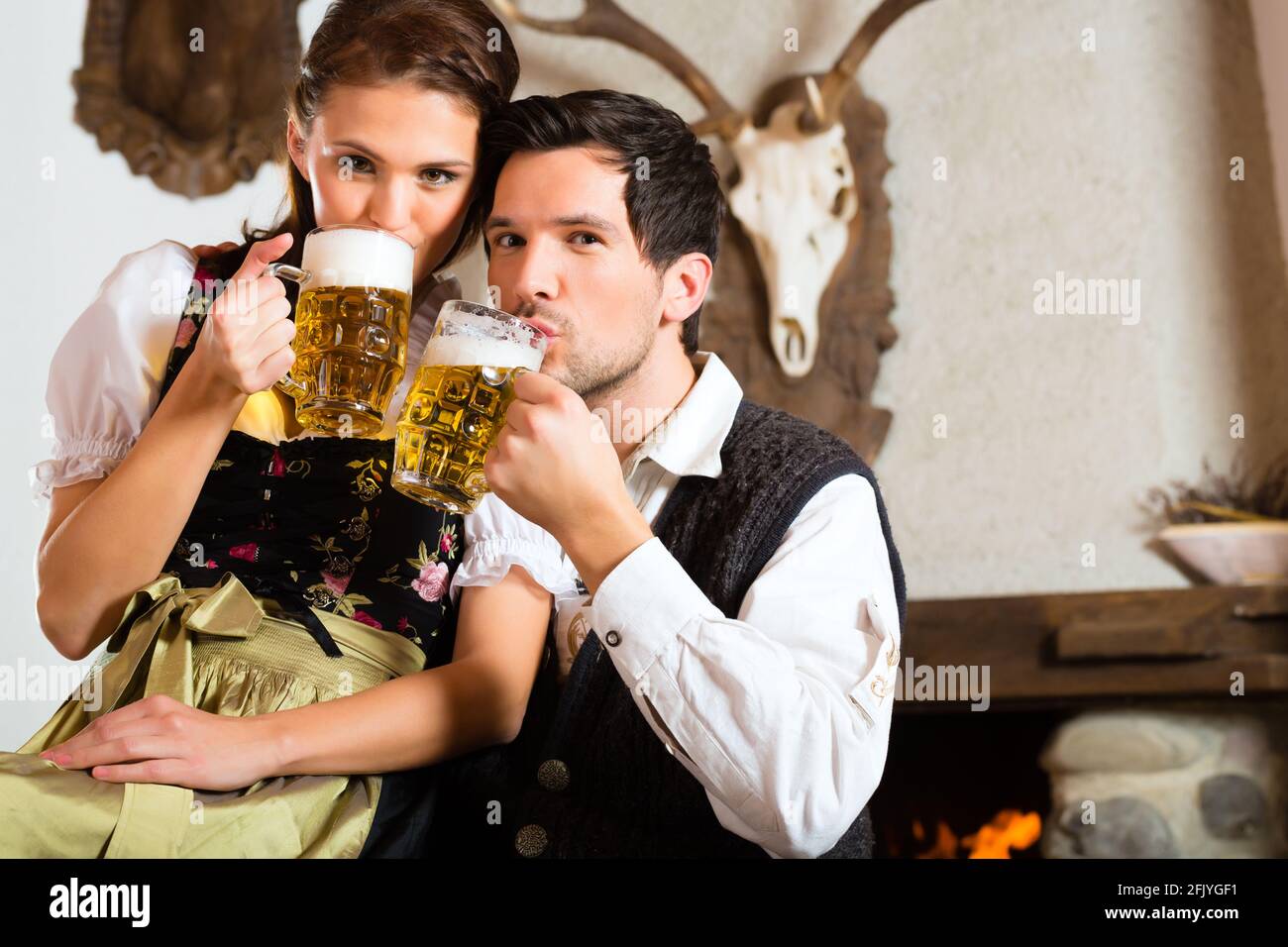 Couple in a traditional mountain hut with fireplace drinking beer Stock ...