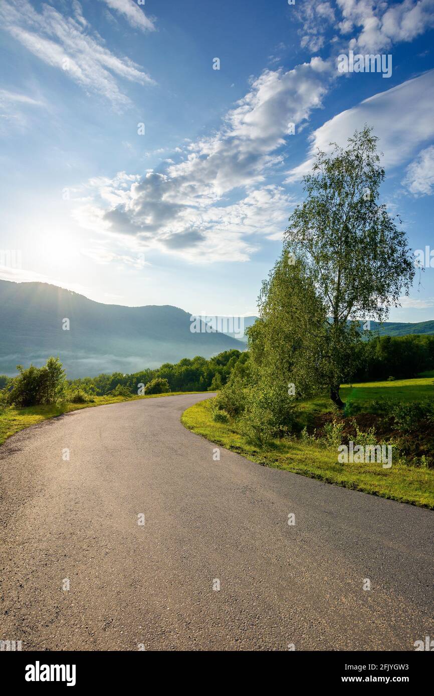 country road down the hill. beautiful travel background. sunny morning ...