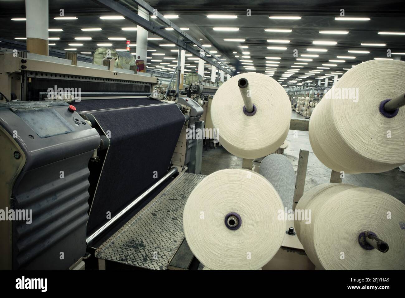 Weaving fabric on air jet looms in big textile weaving unit Stock Photo ...