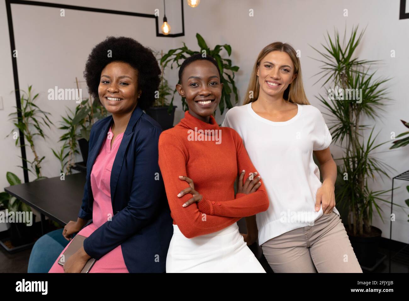 Portrait of diverse group of female business colleagues smiling to ...