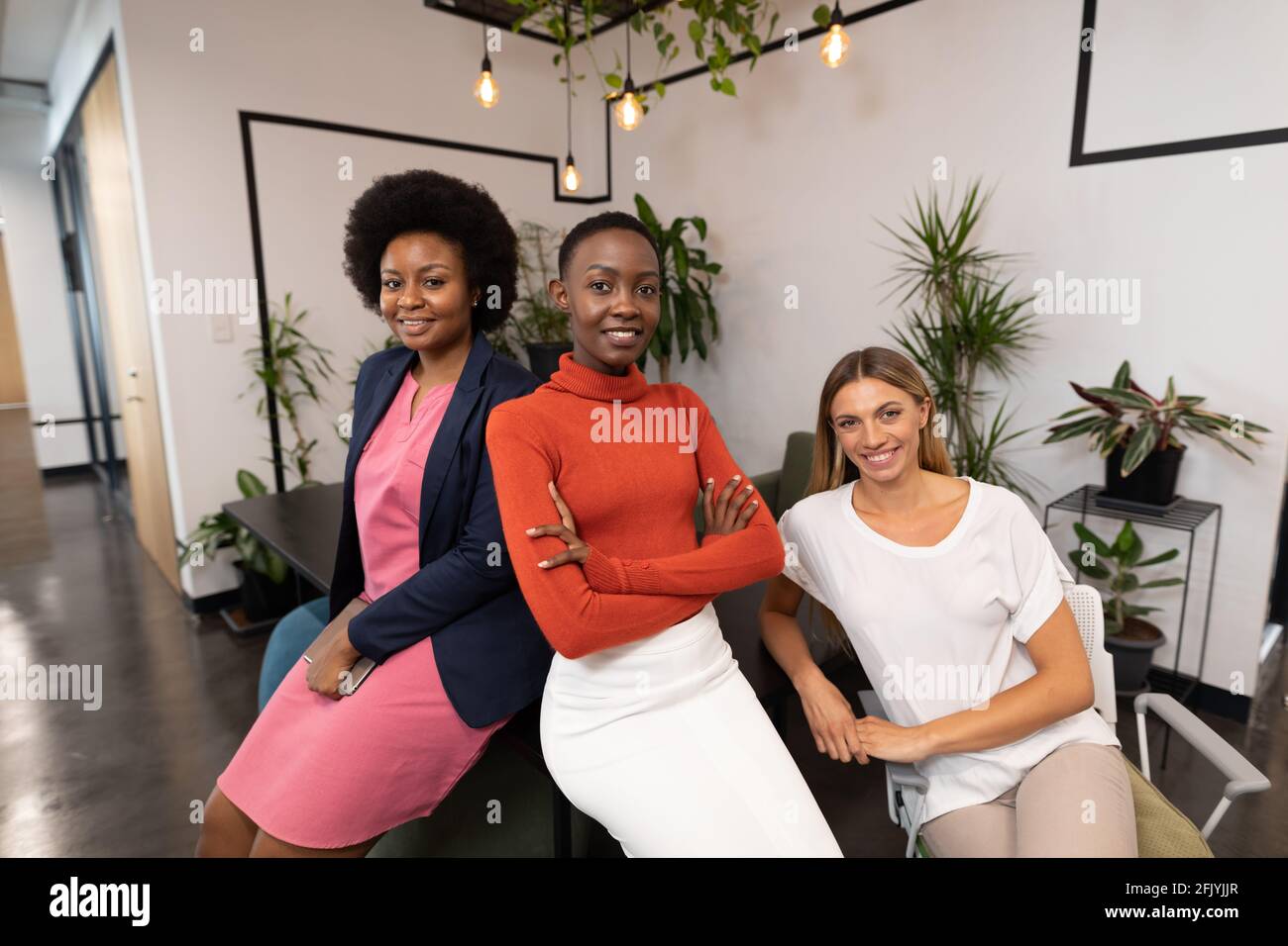 Portrait of diverse group of female business colleagues smiling to ...