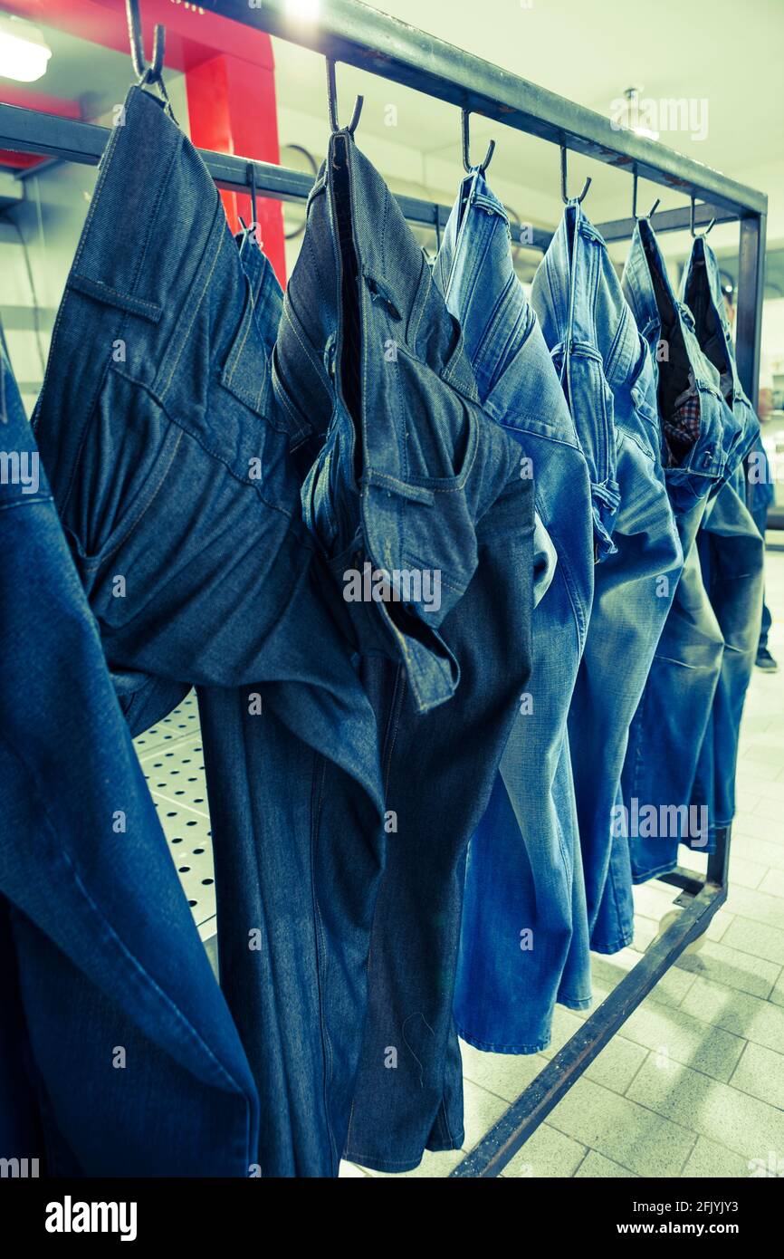 Jeans pants getting spray paints for special effects in denim ...