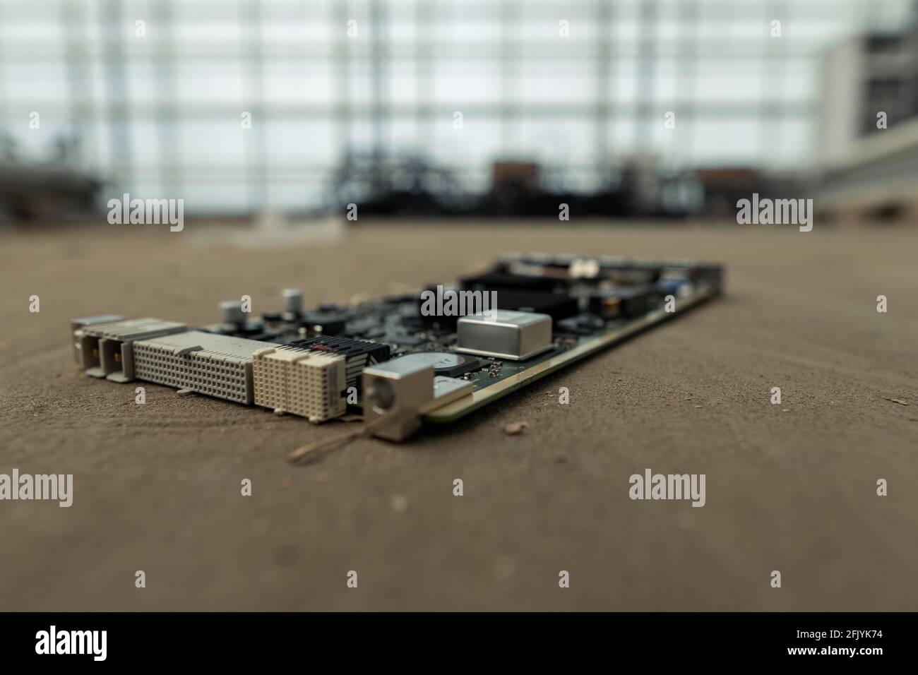 Dismantled computer board lying on the floor in an abandoned warehouse ...