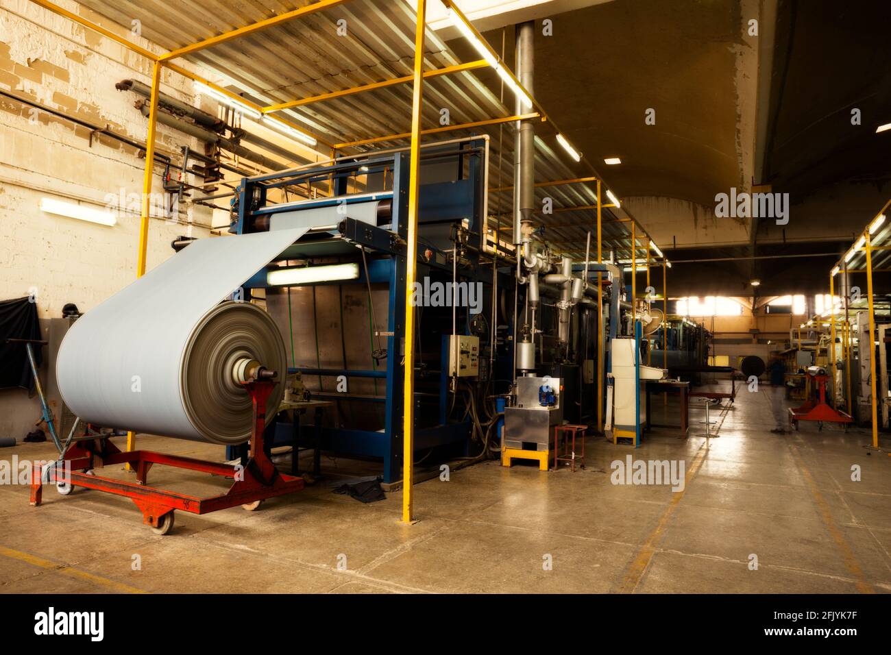 Denim getting steamed press in rolls in denim manufacturing industry ...