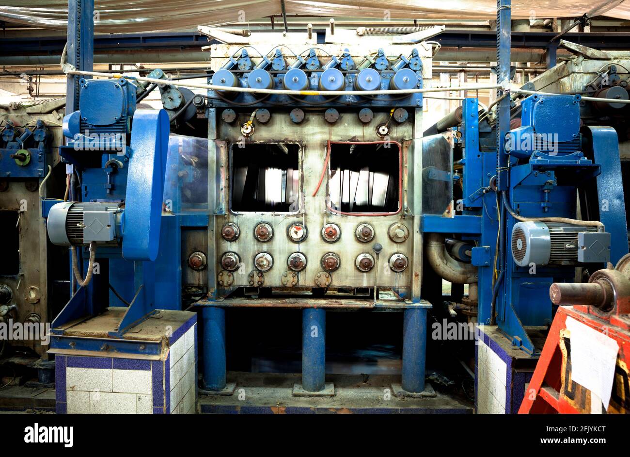 Denim fabric rolls through chemical tanks for finishing treatment in ...