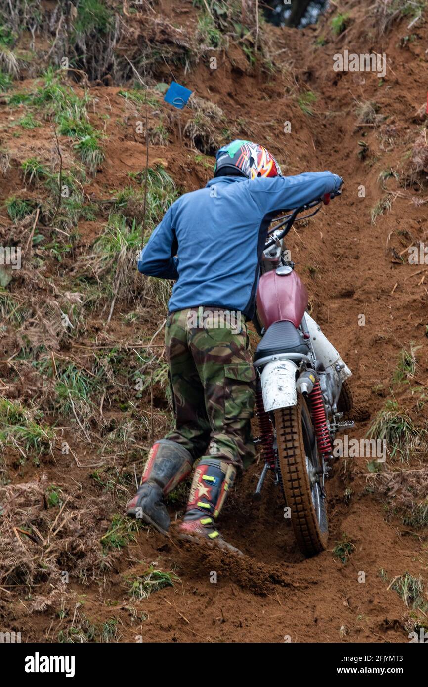 At a Suffolk Sandlings motorcycle trial the sandy soil of a steep slope ...