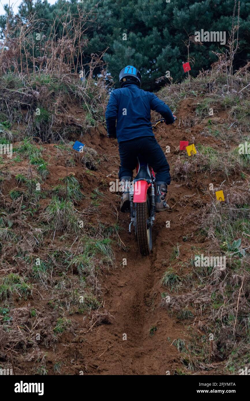 At a Suffolk Sandlings motorcycle trial the sandy soil of a steep slope ...