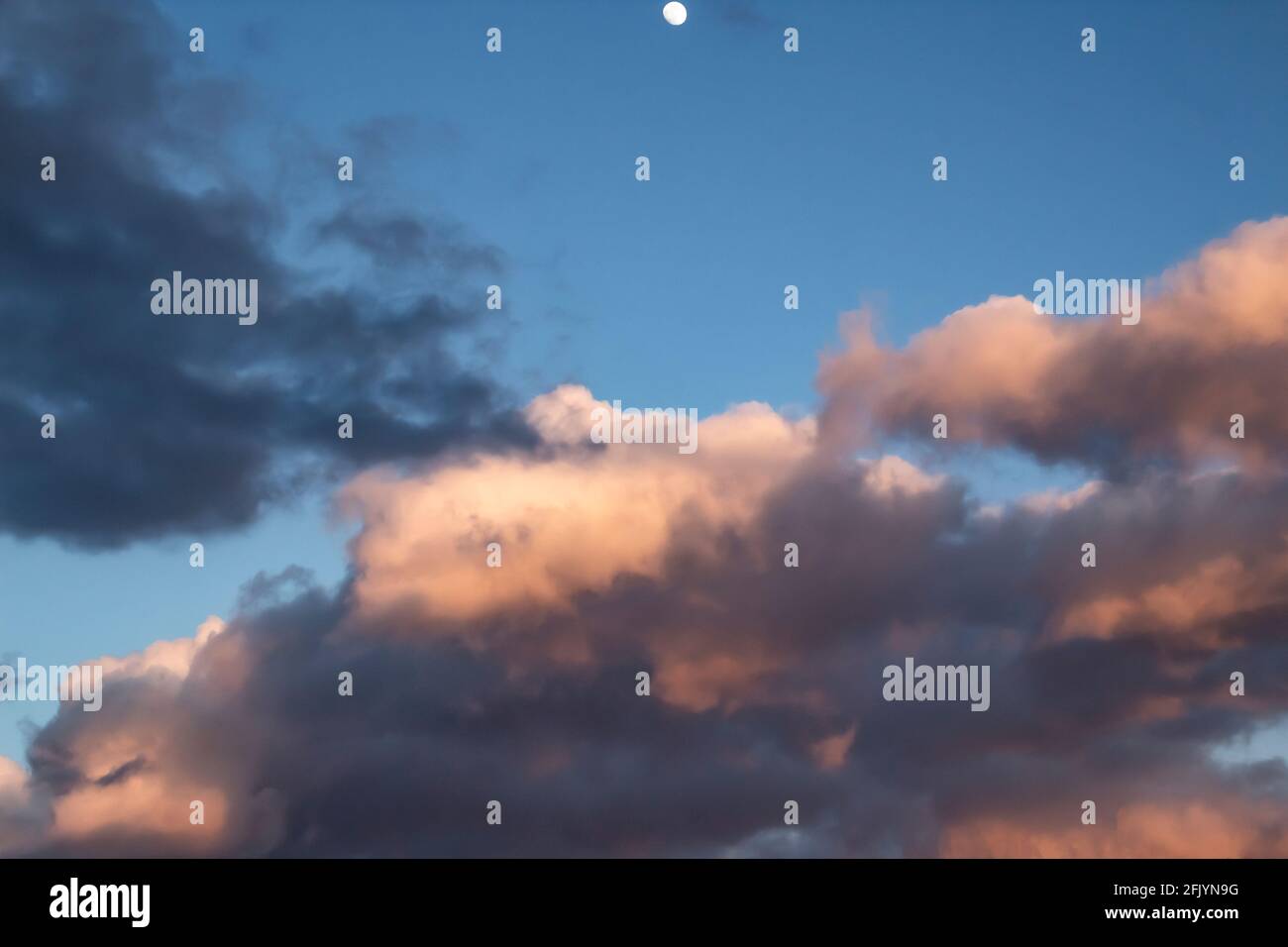 A beautiful dark clouds in the blue sky with moon against background ...