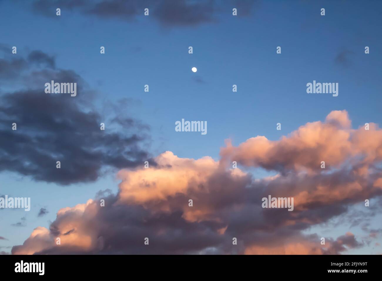 A beautiful dark clouds in the blue sky with moon against background ...
