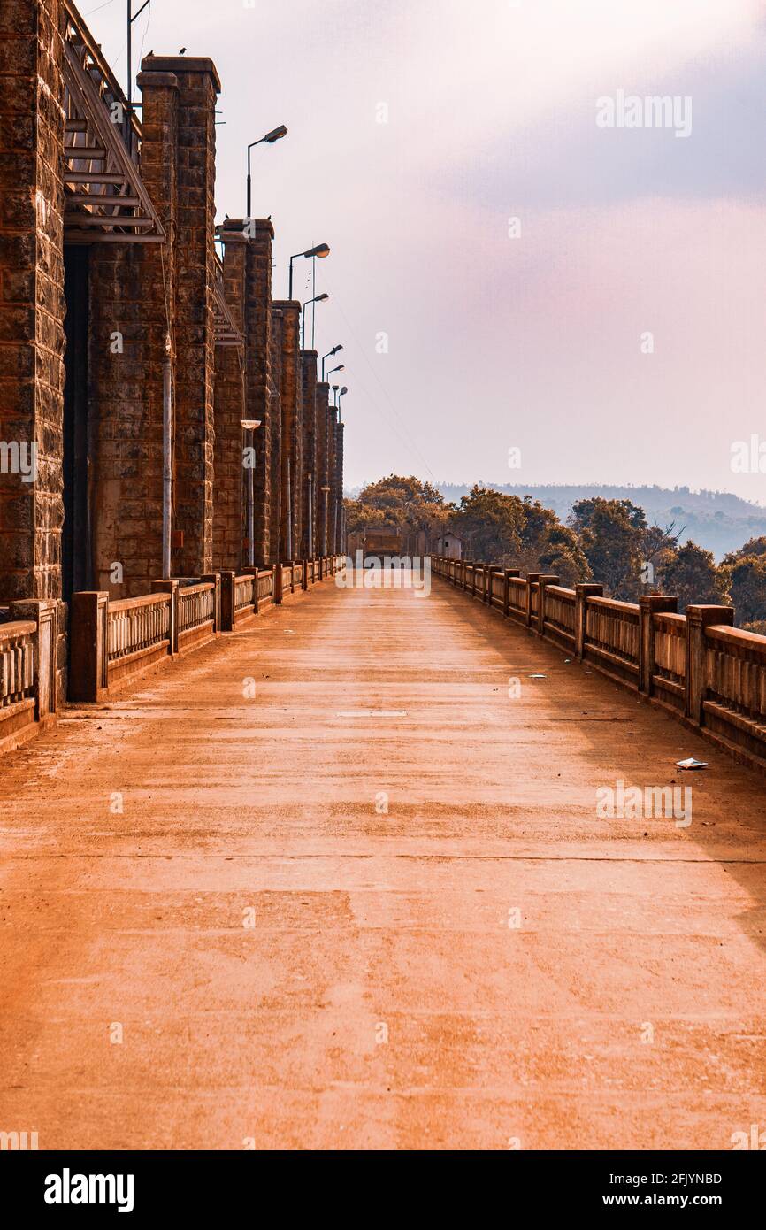 Beautiful alley by a stone bridge columns on a sunny day Stock Photo ...