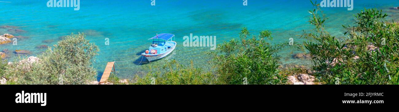 Blue fishing boat in blue sea bay Stock Photo - Alamy