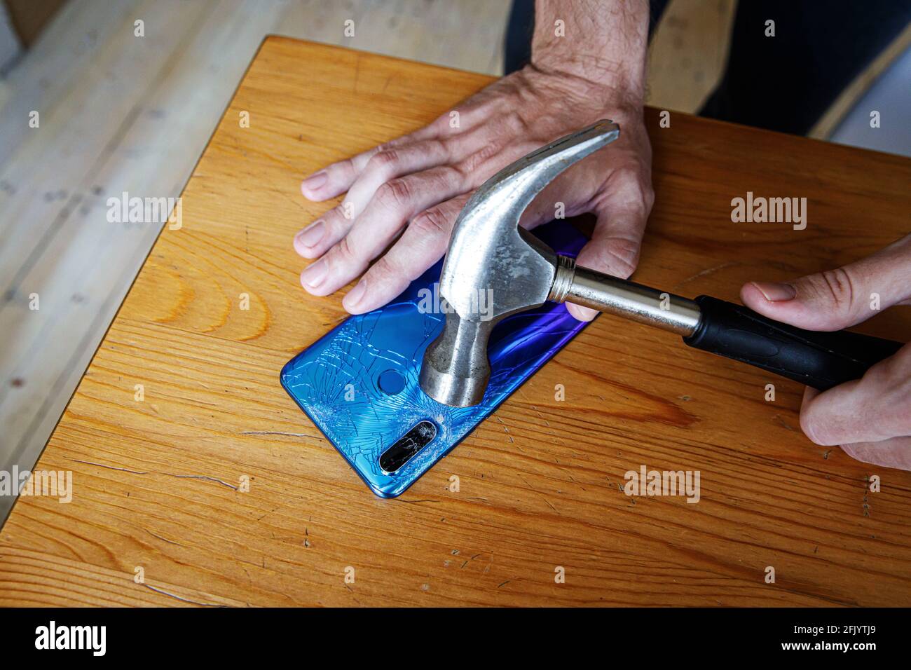 Broken smartphone camera and hammer on wooden background Stock Photo ...
