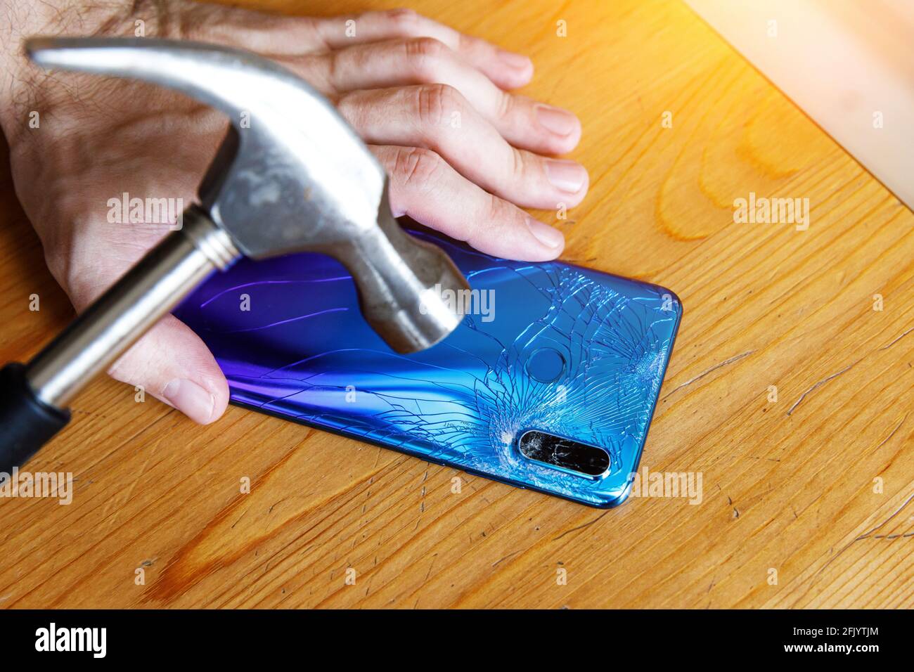 Broken smartphone camera and hammer on wooden background Stock Photo ...