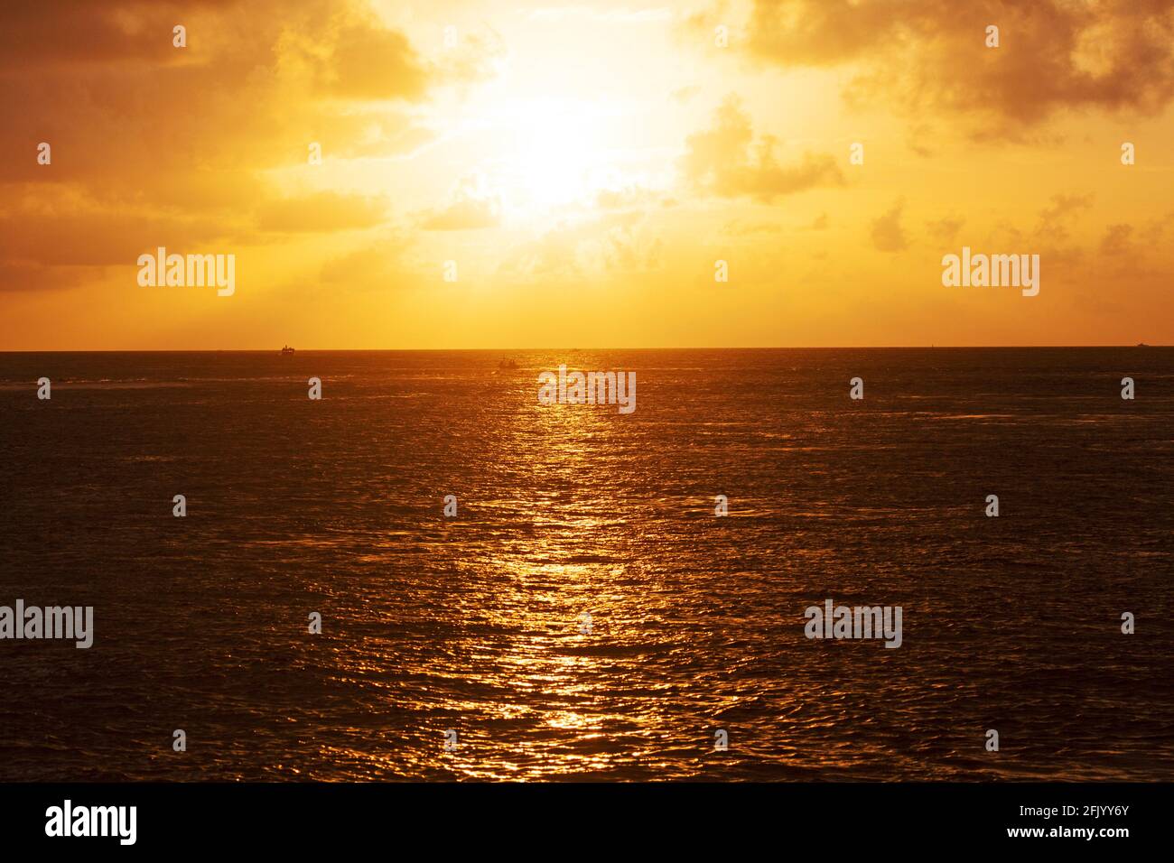 Sundown over the Indian Ocean in in the Maldives. Sunlight glints off ...