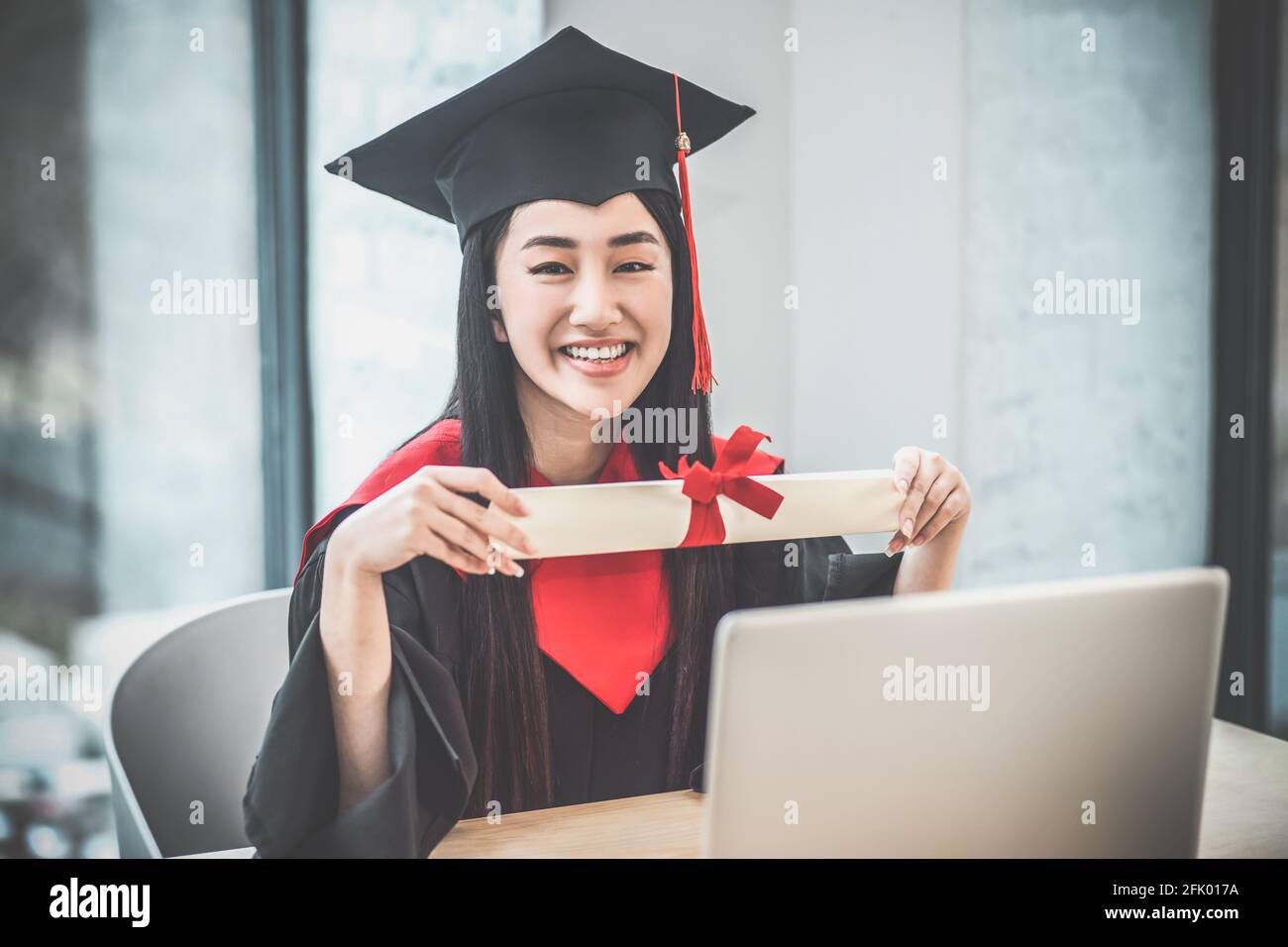 Cute asian smiling graduate holding her diploma and looking happy Stock ...
