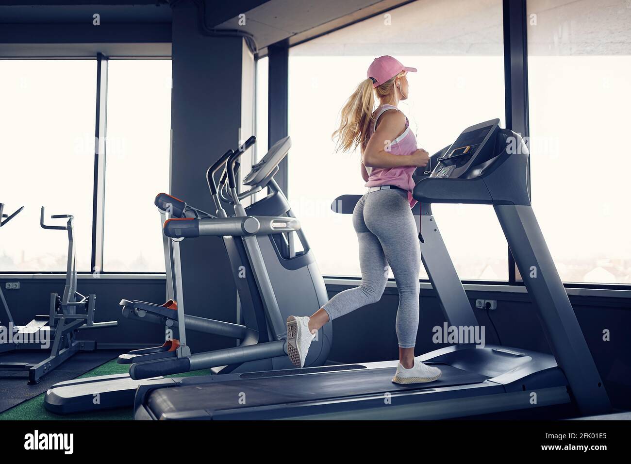 Side view of sporty blonde woman exercising on treadmill in gym Stock ...