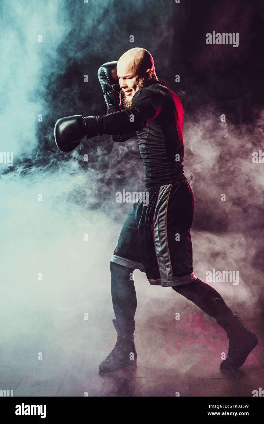 Sportsman boxer fighting on black background with smoke. Boxing Stock ...